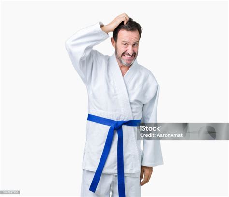 잘생긴 중 년 수석 사람 고립 된 배경 위에 착용 기모노 유니폼 혼동 하 고 질문에 대해 궁금해 의심 불확 실한 손으로 머리에 생각 잠겨있는 개념 가라테에 대한 스톡 사진