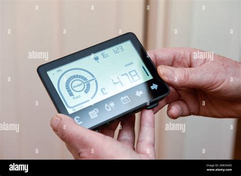 A Senior Woman Looks At The Smart Meter To Budget For Energy Bills For The Household Stock Photo
