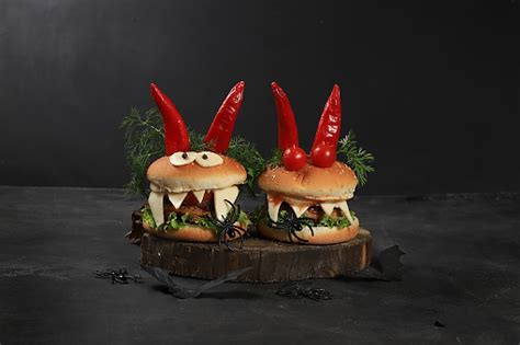 할로윈 음식 개념 신선한 파슬리 잎 토마토 크림 치즈 양파 및 커틀릿을 오래된 콘크리트 배경에 담은 무서운 햄버거 낮은 키 음식