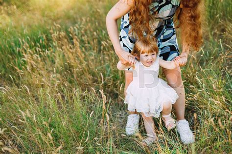 Mother Bent Over Her Daughter And Holds Her By The Arms Stock Image Colourbox