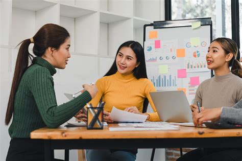 비즈니스 전략과 아이디어에 대해 논의하는 세 명의 여성과의 협업 회의 그들은 차트와 메모로 둘러싸여 대화에 참여하며 팀워크와 창의성을 보여줍니다 25 29세에 대한 스톡