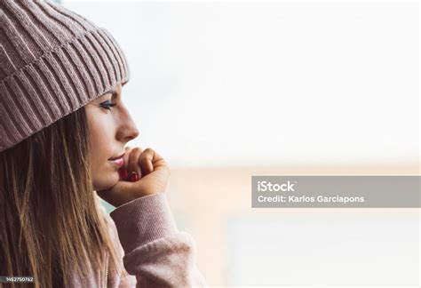 모자를 쓰고 창문 옆에 있는 옆모습의 여자가 웃고 있다 행복과 휴식의 개념 자연 채광 30 34세에 대한 스톡 사진 및 기타 이미지 30 34세 가정 생활 개념