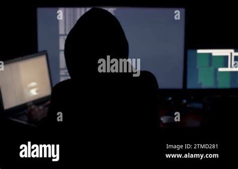Hacker In Hood Cracking Code Using Computers In Dark Room Stock Video