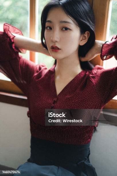우아한 빨간 셔츠를 입고 방의 창문에 머리를 고정하는 한국 여성 기대기에 대한 스톡 사진 및 기타 이미지 기대기 벽 빨강