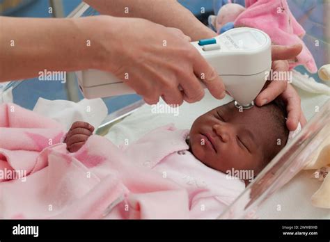 Midwife Measuring The Bilirubin Level In A Newborn Using A