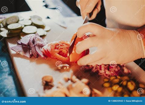 Tomate Del Corte Del Cocinero De La Cocina En La Tabla De Cortar Foto De Archivo Imagen De