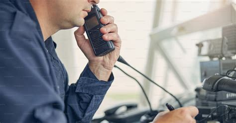 정보를 전송하는 동안 손에 워키토키를 들고 있는 진지한 남자의 자른 머리 초상화 사진 Unsplash의 기술 이미지