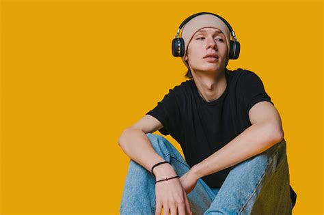 헤드폰을 끼고 생생한 노란색 배경을 배경으로 자신 있게 포즈를 취하고 있는 스타일리시한 청년 개성 개념에 대한 스톡 사진 및 기타 이미지 Istock