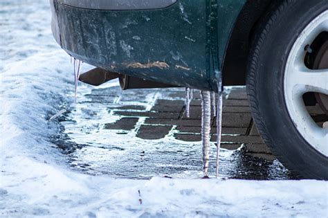 얼음과 서리가 내린 날에 대한 자동차 보험의 필요성과 함께 겨울에 도시 드라이브 문제에 대한 극단적 인 저온눈보라 후 타이어쇼 미끄러운 거리와 자동차에 매달려 긴 고드름 0