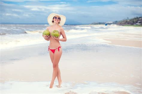 Happy Young Woman Topless With Coconuts In Straw Hat With On The Beach