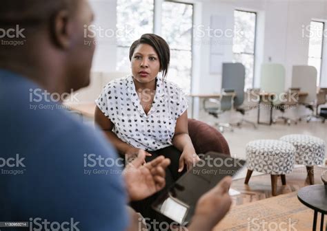 아름 다운 검은 아프리카 비즈니스 여자 회의 중에 남자에 게 진지 하 게 보고 남자는 디지털 태블릿을 들고 있다 현대적인 공동