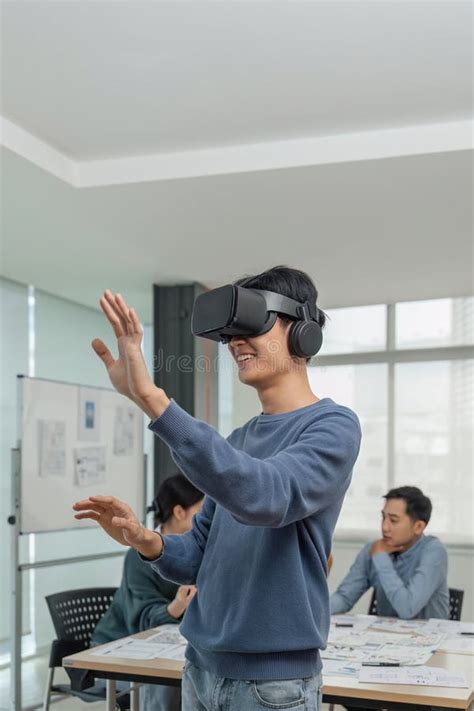 A Cheerful And Excited Young Asian Male Developer Tested A New Vr Game On A Vr Headset In The