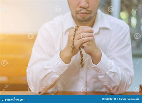 A Faithful Asian Young Male Hands In Prayer Gesture Sitting Alone On