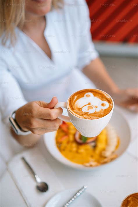 한 여자가 커피 한 잔을 들고 있다 사진 Unsplash의 커피 컵 이미지