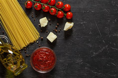 생 스파게티 체리 토마토 파마산 치즈 올리브 오일 향신료 토마토 소스 이탈리아 파스타 상단 보기 어두운 배경 텍스트를 복사 할 수있는 공간 건강한 생활방식에 대한 스톡 사진