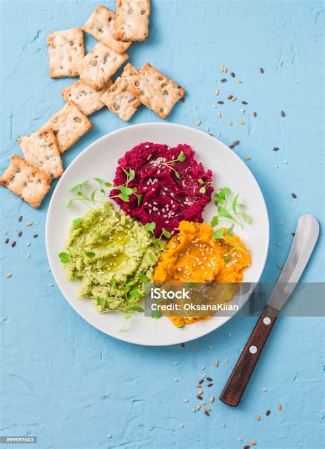 크래커와 후 머 스의 변형입니다 호박 심 황 아보카도 올리브 오일 참 깨와 마이크로 녹색 파란색 배경에 평면도 근대 후 머 스 강황에 대한 스톡 사진 및 기타 이미지