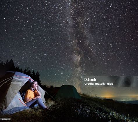 밤 별이 빛나는 하늘 아래 캠프 텐트에 앉아 아름다운 소녀 등산객 밤 하루 시간대에 대한 스톡 사진 및 기타 이미지 밤 하루 시간대 캠핑 텐트 Istock