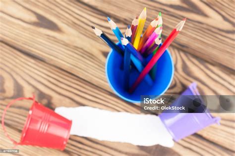 색연필 찢어진된 흰색 빈 종이와 오래 된 갈색 나무 테이블에 두 개의 금속 작은 빈 양동이 빨간색과 보라색 색상 블루 플라스틱 유리에서 많은 0명에 대한 스톡 사진 및 기타