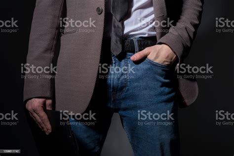 청바지와 정장 정장에 남자의 클로즈업 그의 손에 폴더를 보유하고 비즈니스 스타일 어두운 배경에 아트 라이트 남성 의류의 광고 사진입니다 남성 패션 룩 경제학자에 대한 스톡