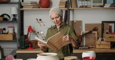 차고에 서 있는 동안 정원 가꾸기 또는 국내 꽃 재배에 대해 열린 책을 읽는 현대 활동적인 은퇴 여성 사진 Unsplash의 도기 이미지