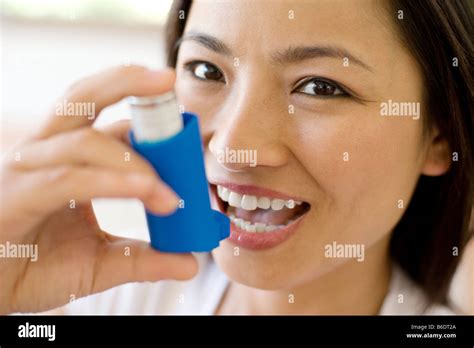 Asthma Inhaler Use Woman Using An Inhaler To Treat An Asthma Attack