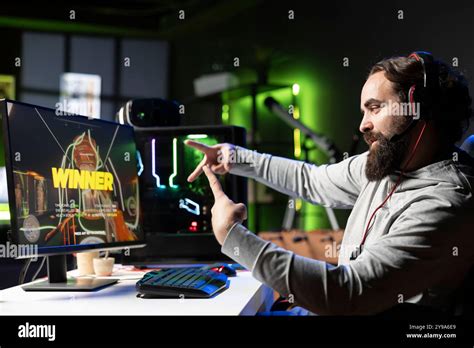 Der begeisterte Gamer feiert nachdem er den Siegerbildschirm für das Töten aller Feinde und das