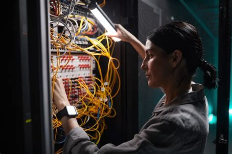 Premium Photo Side View Portrait Of Female Network Engineer Connecting Cables In Server