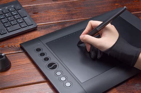손은 그래픽 태블릿에 그립니다 프리랜서 디자이너 일러스트 레이터 기술 원격 작업 아웃소싱 그래픽 태블릿용 장갑과 펜 디지털 태블릿에서 작업하는 그래픽 디자이너 프로젝트 검은