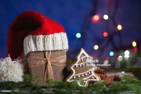 크리스마스와 새해 선물 상자 크리스마스 트리 가지와 화환 파란색 배경에 산타 모자에 크래프트 종이에 포장 크리스마스 트리 모양의 쿠키 12월에 대한 스톡 사진 및 기타