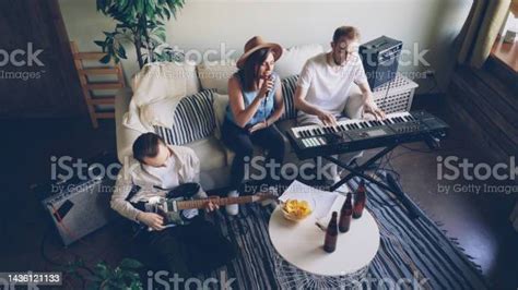 홈 스튜디오에서 리허설 음악 밴드의 높은 각도 보기 활성 감정적인 젊은 사람들은 악기 키보드와 기타를 연주하 고 노래 가정 생활에 대한 스톡 사진 및 기타 이미지 Istock