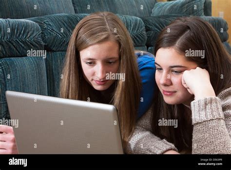 Two Teenage Girls On Living Room Floor Intently Studying Laptop Stock Photo Alamy