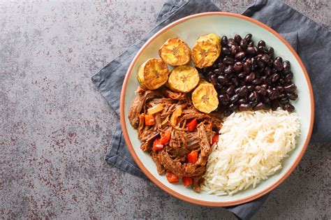 파베욘 크리올로 베네수엘라의 국가 요리는 갈가리 찢긴 쇠고기 쌀 검은 콩 튀긴 질경이를 접시에 근접 촬영합니다 수평 평면도 갈기갈기 찢어진에 대한 스톡 사진 및 기타 이미지