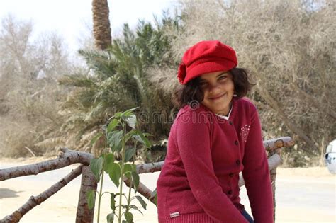 Young Girl Wearing A Red Headpiece And Smiling Under The Sunlight Of