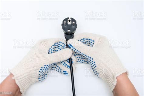 보호 장갑을 착용 한 전기 기술자는 흰색 배경에 플러그가있는 와이어를 잡고 전기 배선 수리 복사 공간을 직접 수행하십시오 깨짐에 대한 스톡 사진 및 기타 이미지 Istock