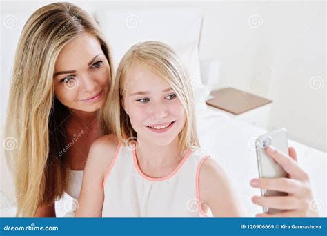 Portrait Of Beautiful Mature Mother And Her Daughter Making A Selfie