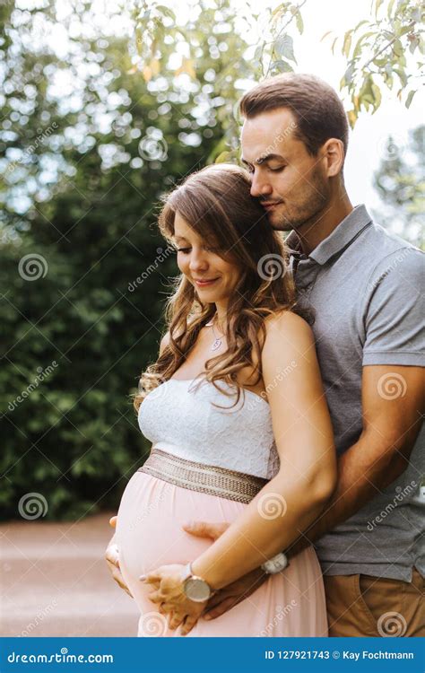 Husband Is Embracing His Beautiful Pregnant Wife From Behind Stock
