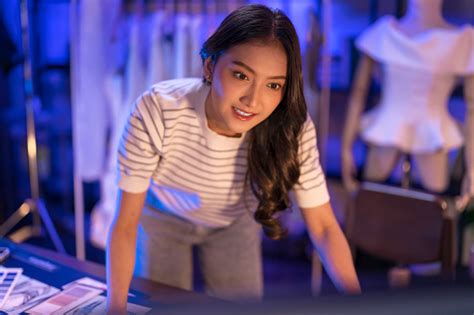 아시아 성인 여성 패션 디자이너 천 재단사 새로운 컬렉션 스케치 드로잉을 위해 일하는 새로운 색상 견본 직물 샘플을 밤에 디자인 스튜디오 홈 스튜디오의 책상에서 선택합니다