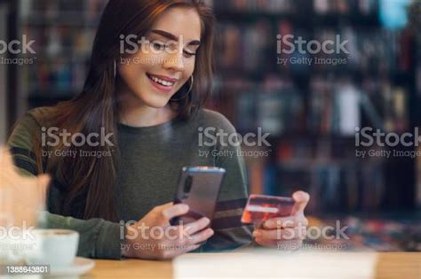 카페에서 온라인 쇼핑을 위한 스마트폰과 신용카드를 사용하는 여성 20 24세에 대한 스톡 사진 및 기타 이미지 20 24세 Brand Name Smart Phone