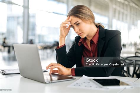 스트레스를 받고 지치고 좌절하고 걱정스러운 백인 여성 회사 직원 제품 관리자 업무용 책상에 앉아 슬프게도 노트북 화면을보고 일에 지치고 프로젝트에 문제가 있습니다 30 34