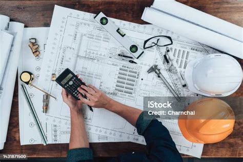 탑 뷰 엔지니어링 사무실 책상 및 삼각형 눈금자 안전 안경 나침반 블루프린트의 버니어 캘리퍼에서 도면 검사 및 프레스 계산기로 작업합니다 엔지니어 건축가 산업 및 공장 개념