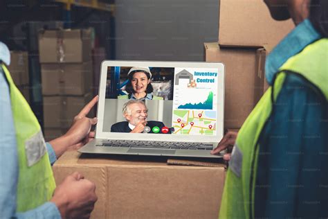 창고 직원은 저장 창고에 있는 컴퓨터 스크린에 화상 통화에 이야기합니다 온라인 소프트웨어 기술은 인터넷 네트워크에서 가상 전화 회의를 통해 물류 공장에서 일하는 사람들을