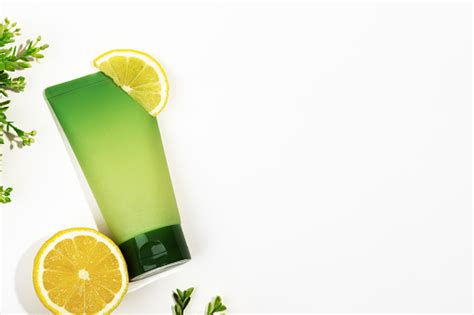 레몬과 식물의 조각녹색 브랜드 튜브의 최고 보기 영양크림 바디 스크럽 로션 또는 자외선 차단제를 위한 플라콘 모형 스타일 복사 공간 스킨케어 및 유기농 미용 개념 문질러