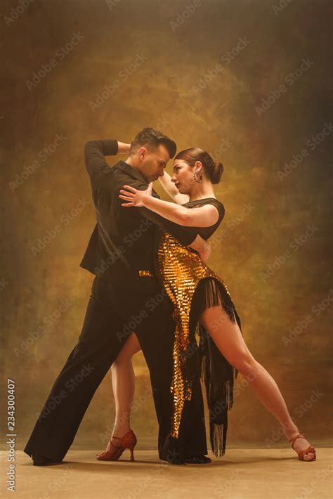 Foto Stock The Young Dance Ballroom Couple In Gold Dress Dancing In
