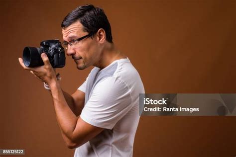 배경색에 대 한 카메라를 사용 하 여 잘생긴 남자의 스튜디오 샷 30 39세에 대한 스톡 사진 및 기타 이미지 30 39세 35 39세 갈색 배경 Istock