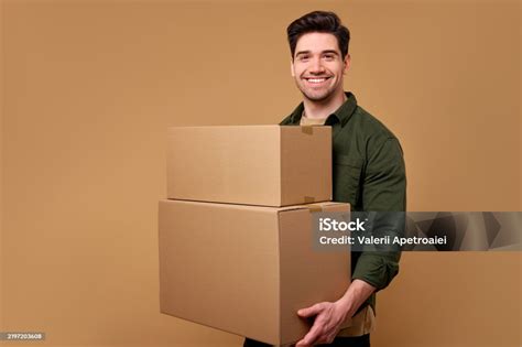 한 남자가 따뜻한 베이지색 배경에 여러 개의 상자를 들고 자신의 노력을 보여주고 있습니다 상자에 대한 스톡 사진 및 기타 이미지 상자 명랑한 행복 Istock