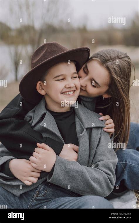 Mother Embracing Son Sitting On Field Stock Photo Alamy