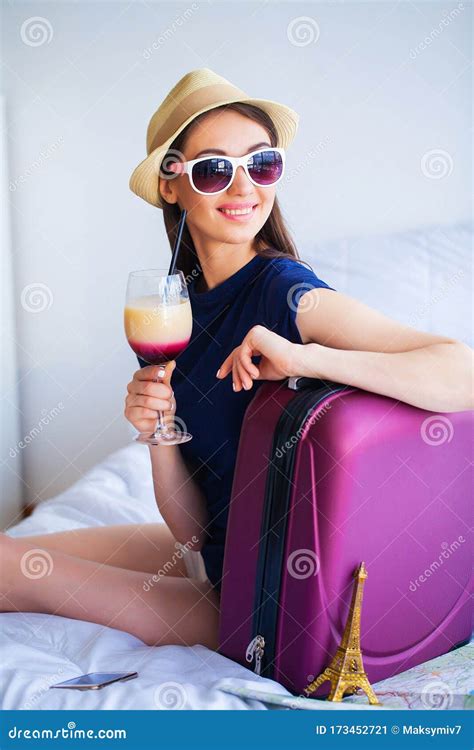 Hermosa Chica Sentada En La Cama Y Se Va De Vacaciones Imagen De Archivo Imagen De Sitio
