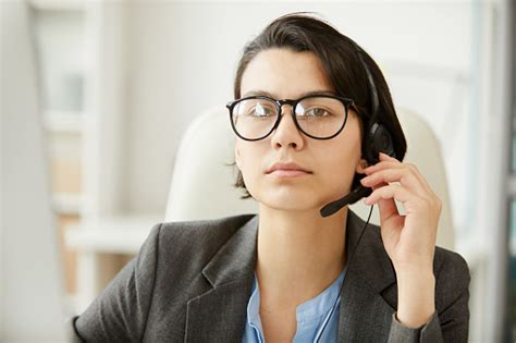 고객과의 커뮤니케이션을 위해 헤드셋을 착용한 안경에 심각한 자신감 있는 아름다운 여성 기술 지원 운영자의 초상화 갈색 머리에 대한 스톡 사진 및 기타 이미지 Istock