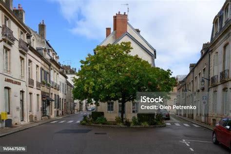 프랑스 부르고뉴 2022년 10월 본의 작은 마을에 있는 두 개의 고대 거리 고대 건물 중세 분위기의 교차로에서 자라는 특이한 나무 본 코트 드 본느에 대한 스톡 사진 및