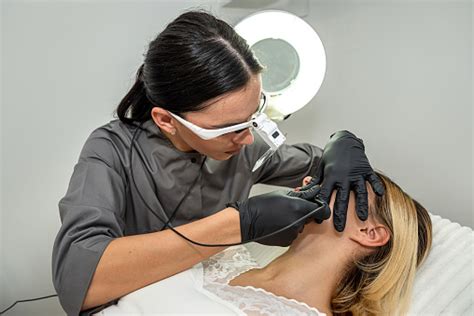 여성 미용사는 클라이언트 Ay 의료 캐비닛을 위해 얼굴에 전기 제모 절차를 만듭니다 2명에 대한 스톡 사진 및 기타 이미지 2명 Electrolysis 건강관리와